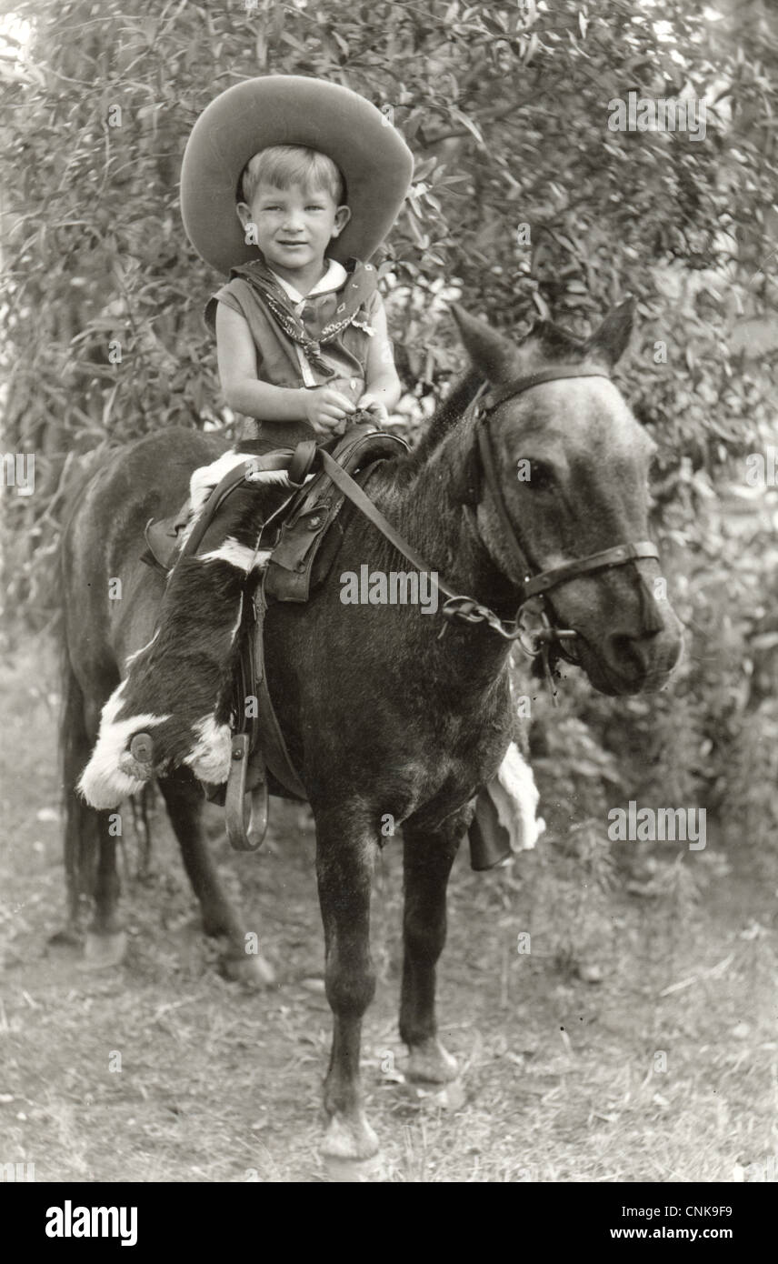 Squinting Little Cowboy Riding a Pony Stock Photo - Alamy