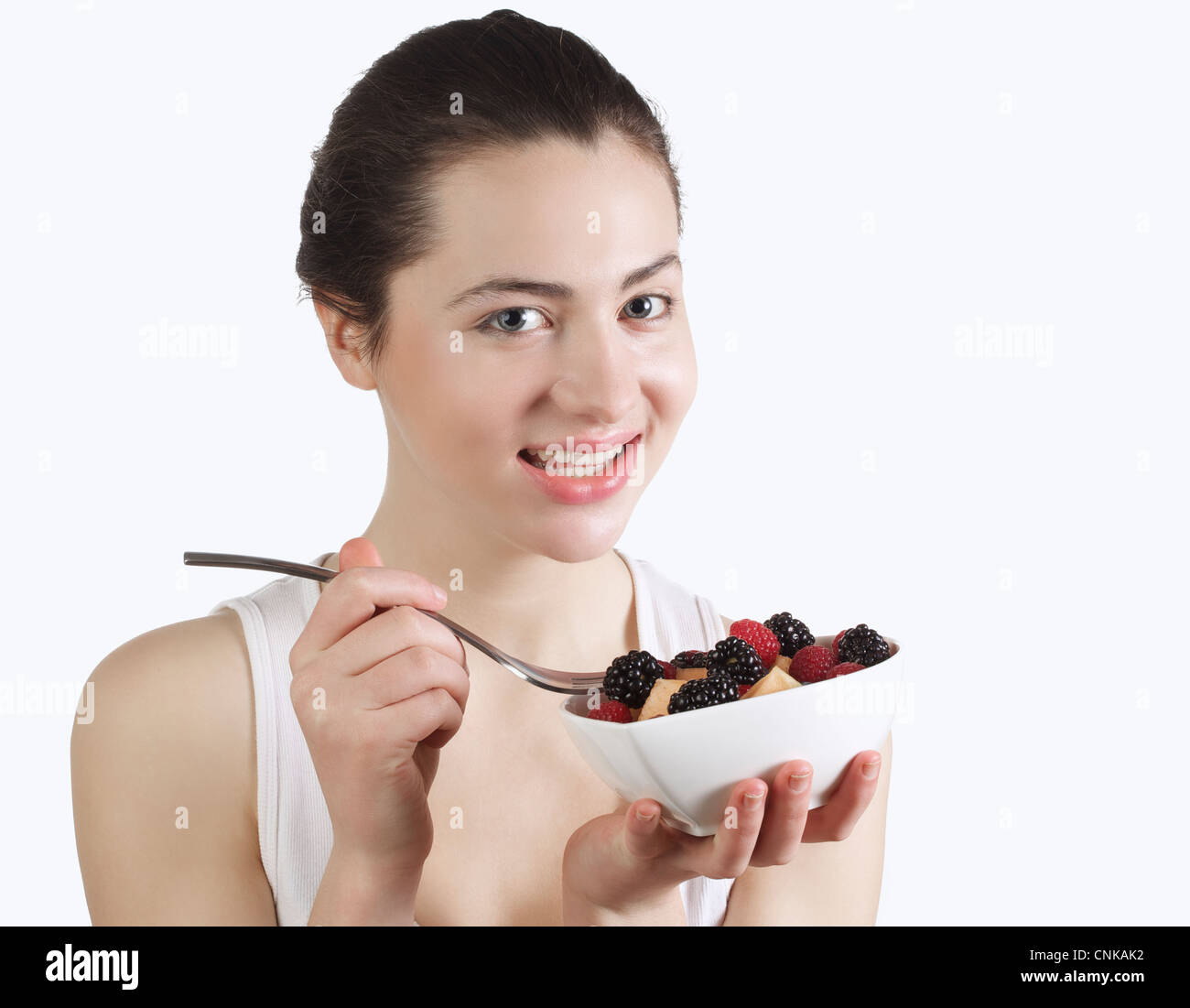 Beautiful young woman eating fruit salad Stock Photo - Alamy