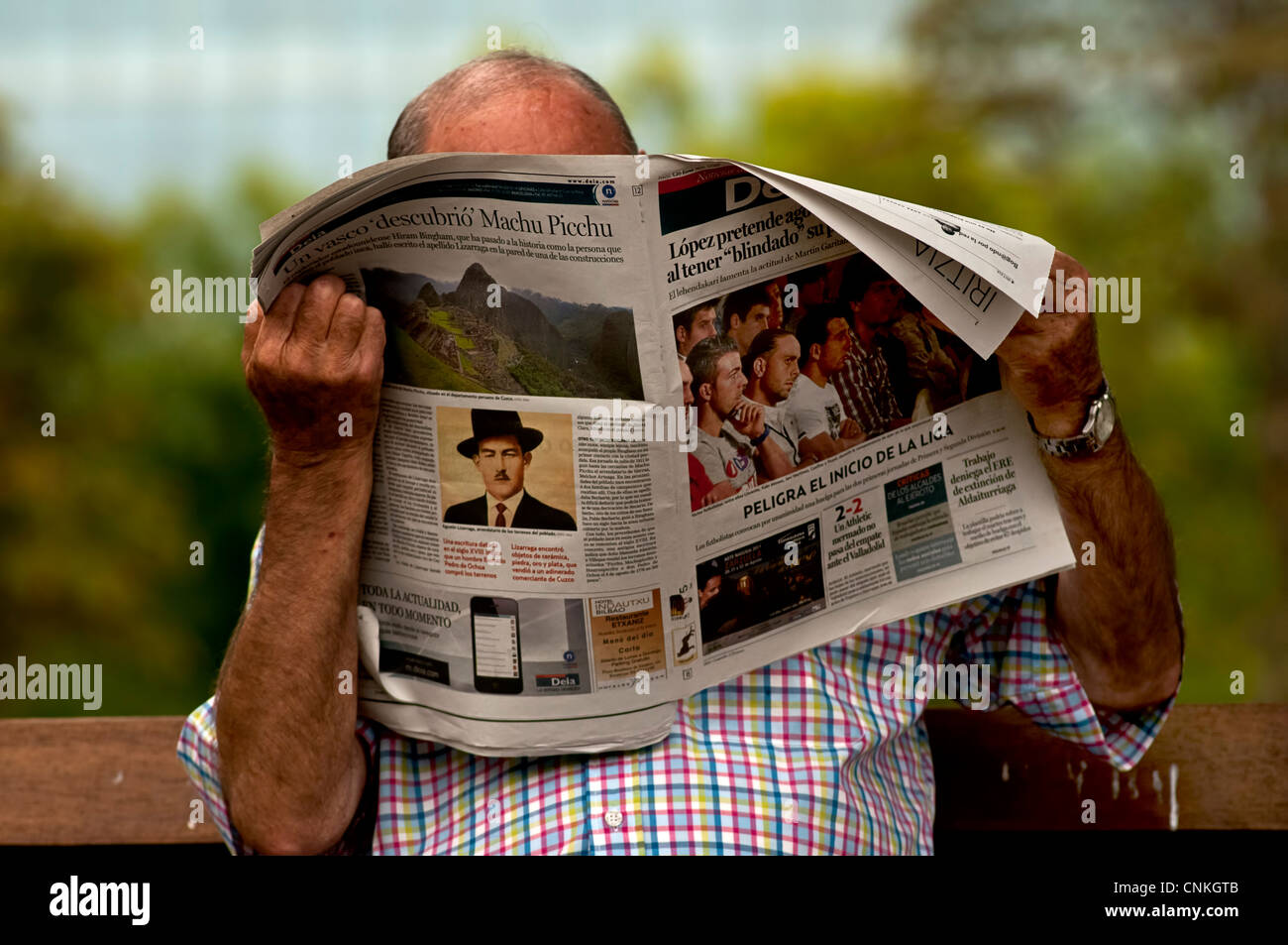 man reading newspaper on park bench in bilbao, basque country Stock ...