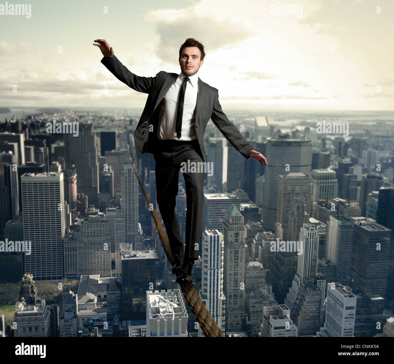 Businessman is balancing on a rope Stock Photo - Alamy