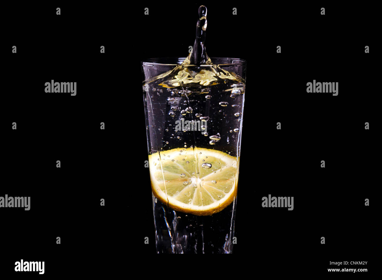 Slice of lemon drop into the glass Stock Photo - Alamy