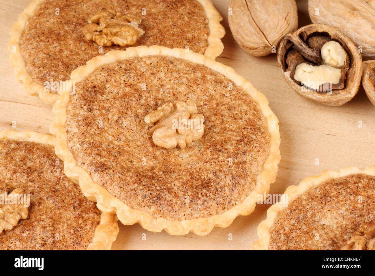 Some walnut mini tarts and some walnuts over a wooden background Stock ...