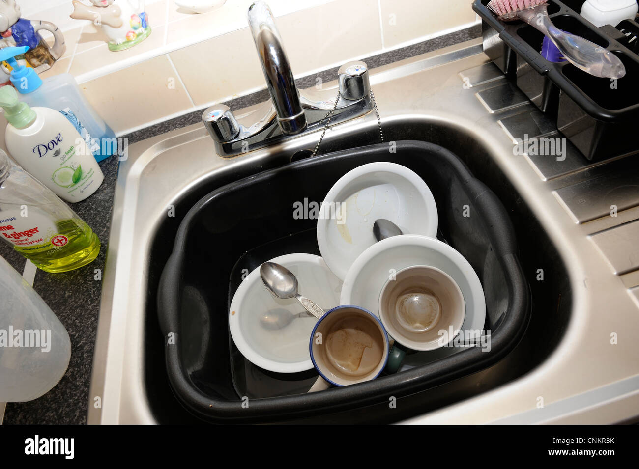 dirty pots waiting to be washed in a sink england uk Stock Photo - Alamy