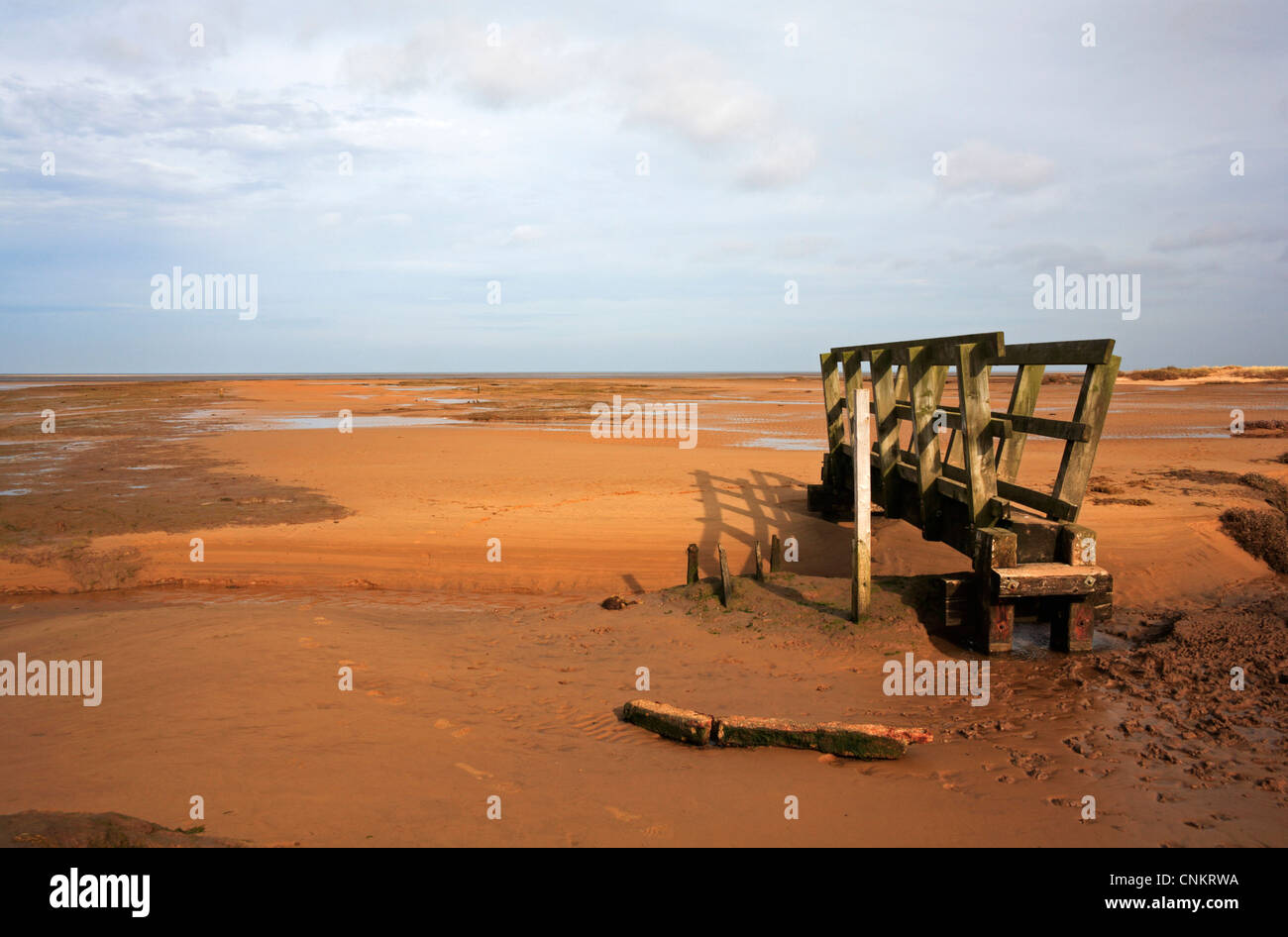 An access bridge to Stiffkey Freshes over a small creek at low tide at ...