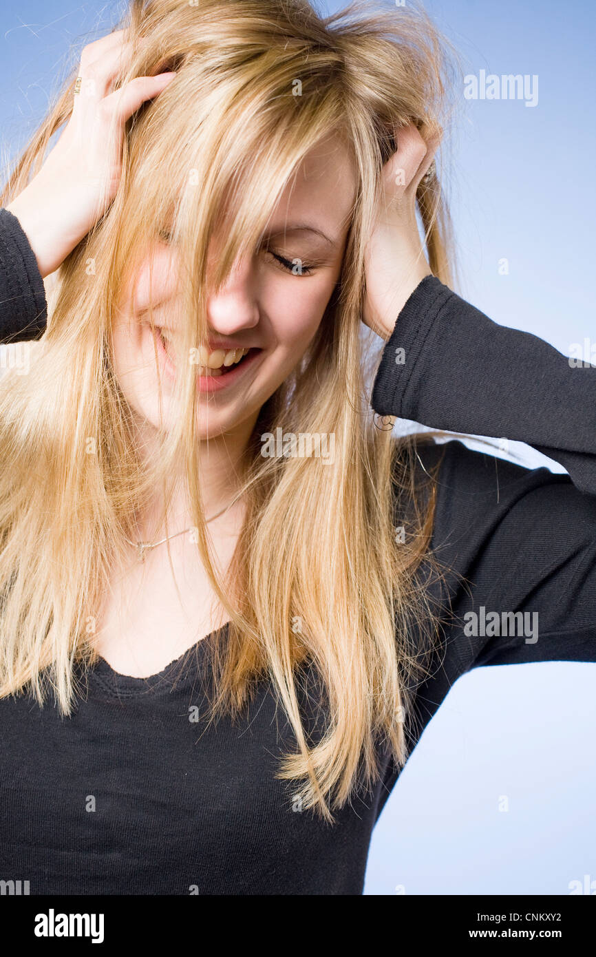 Closeup portrait of an exuberant young blond on blue background Stock ...