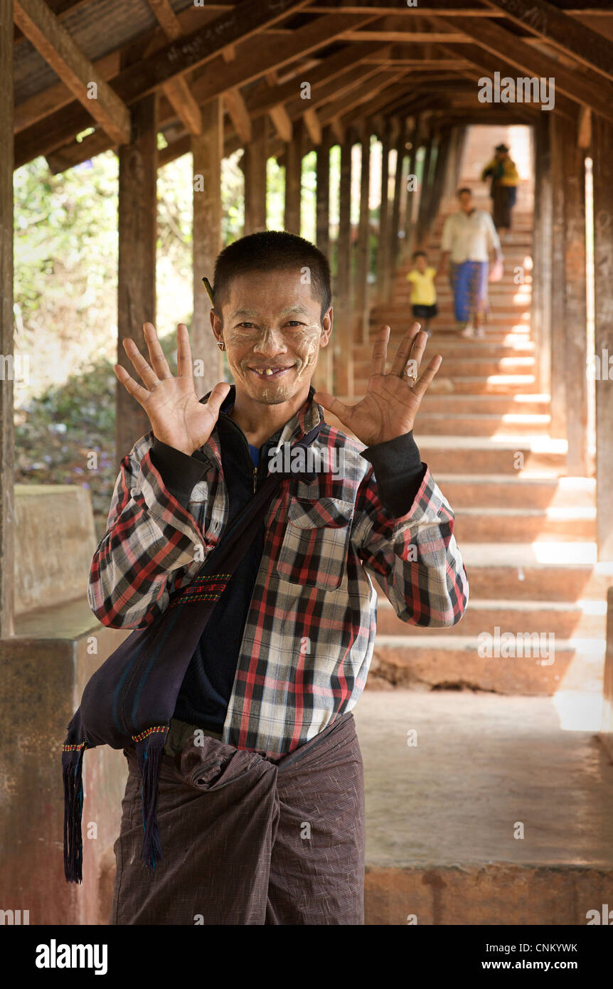 Burmese man with thanaka painted face on the covered walkway steps to ...