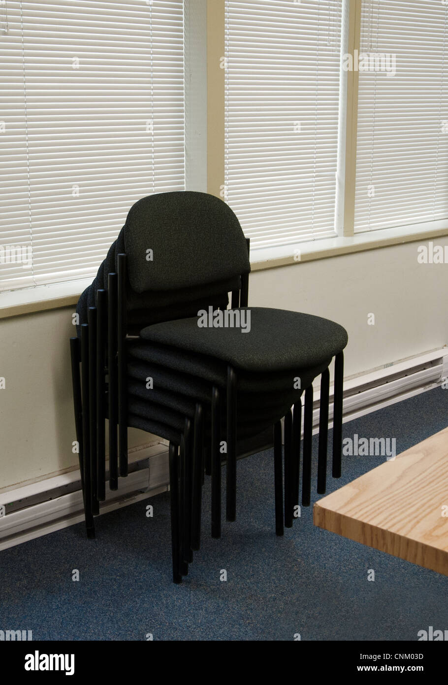 Stack of chairs in empty room Stock Photo - Alamy