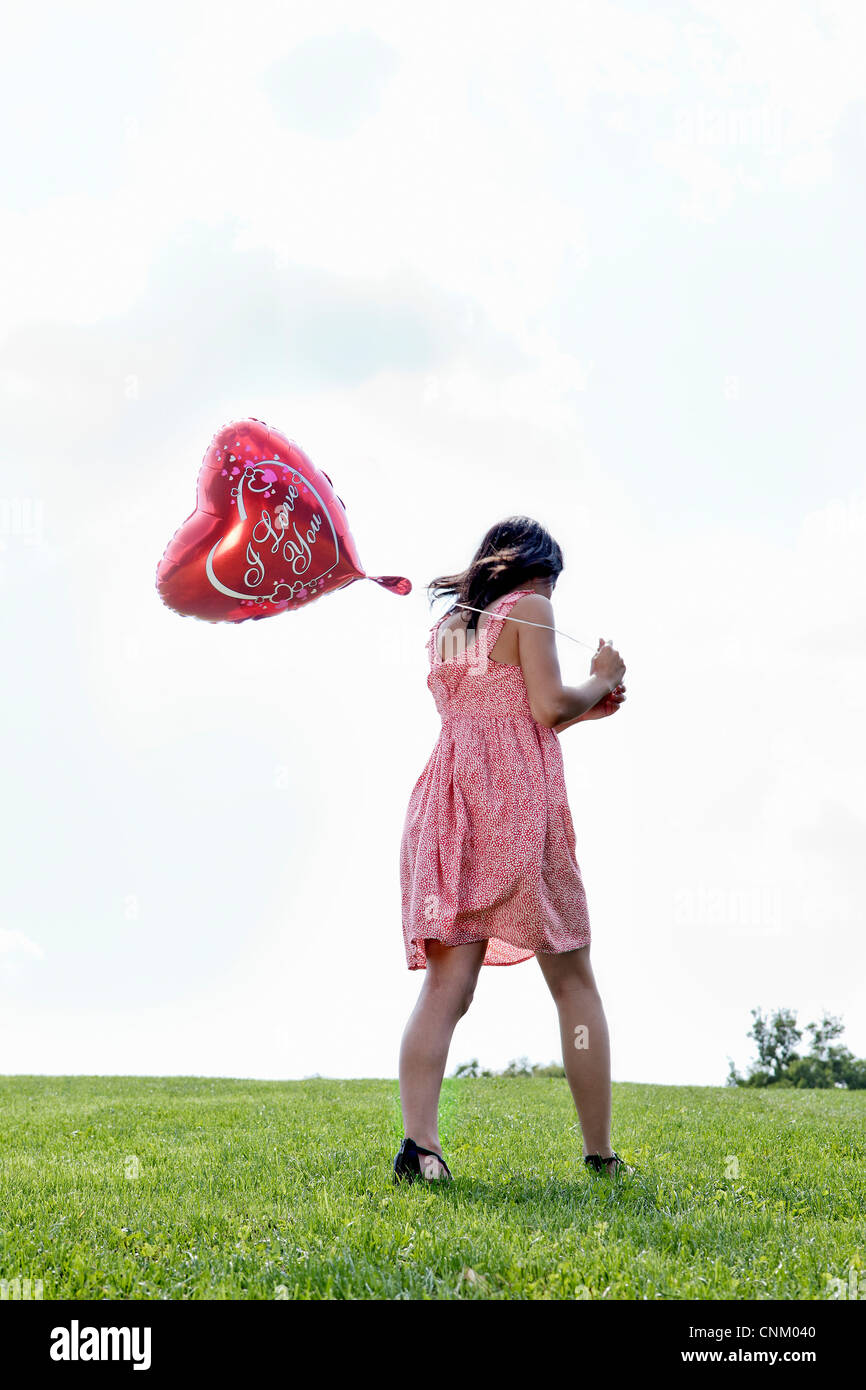 Teenager carrying heart-shaped balloon Stock Photo - Alamy