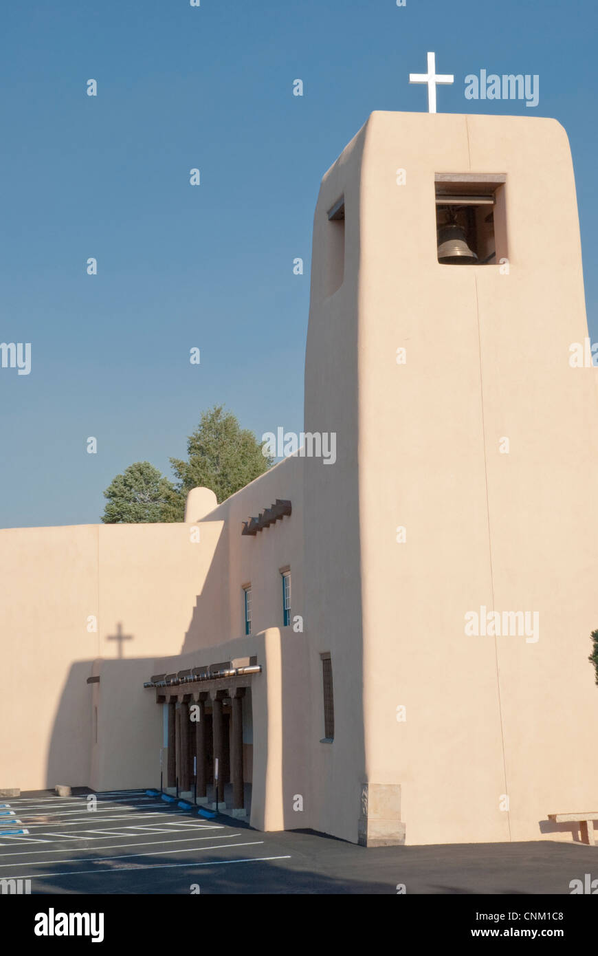 The cross atop the bell tower on the Cristo Rey Catholic Church casts ...