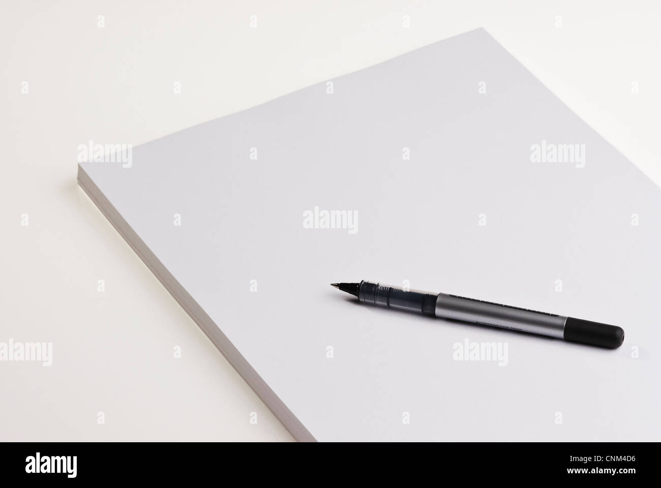 Blank pad of white paper with a pen on a white background Stock Photo ...