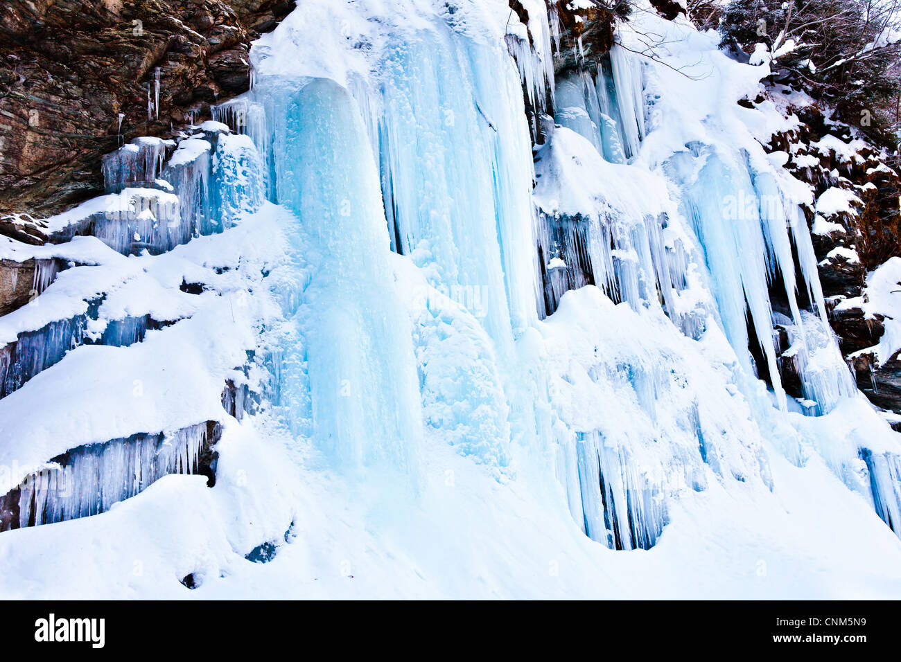 Huge icicles formed in a waterfall on a mountain Stock Photo - Alamy