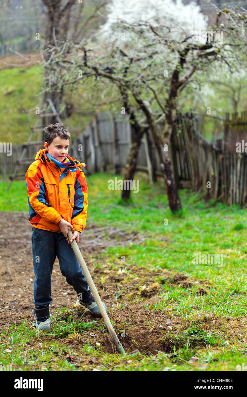 Boy digging on a grass field in the countryside Stock Photo - Alamy