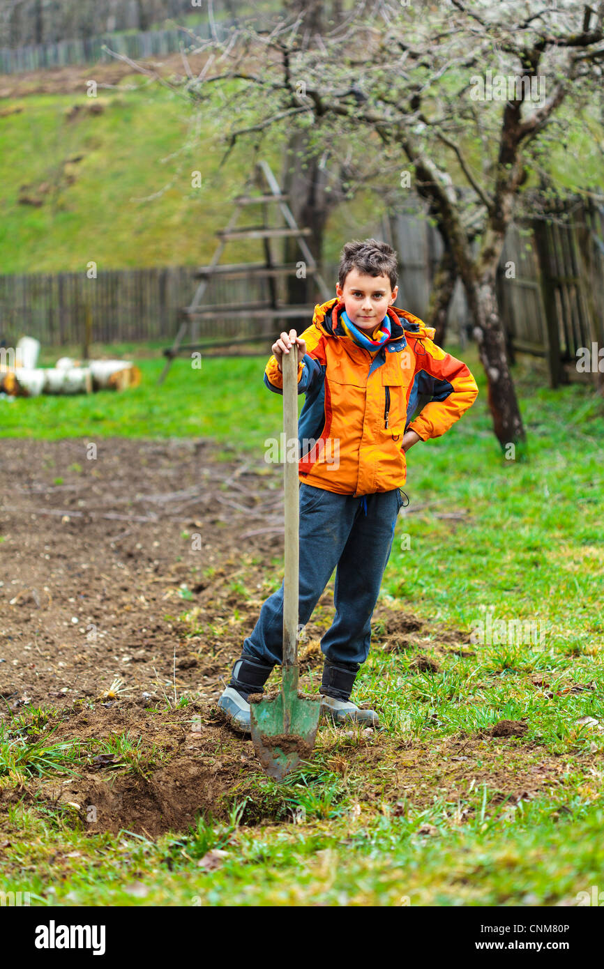 Boy digging on a grass field in the countryside Stock Photo - Alamy