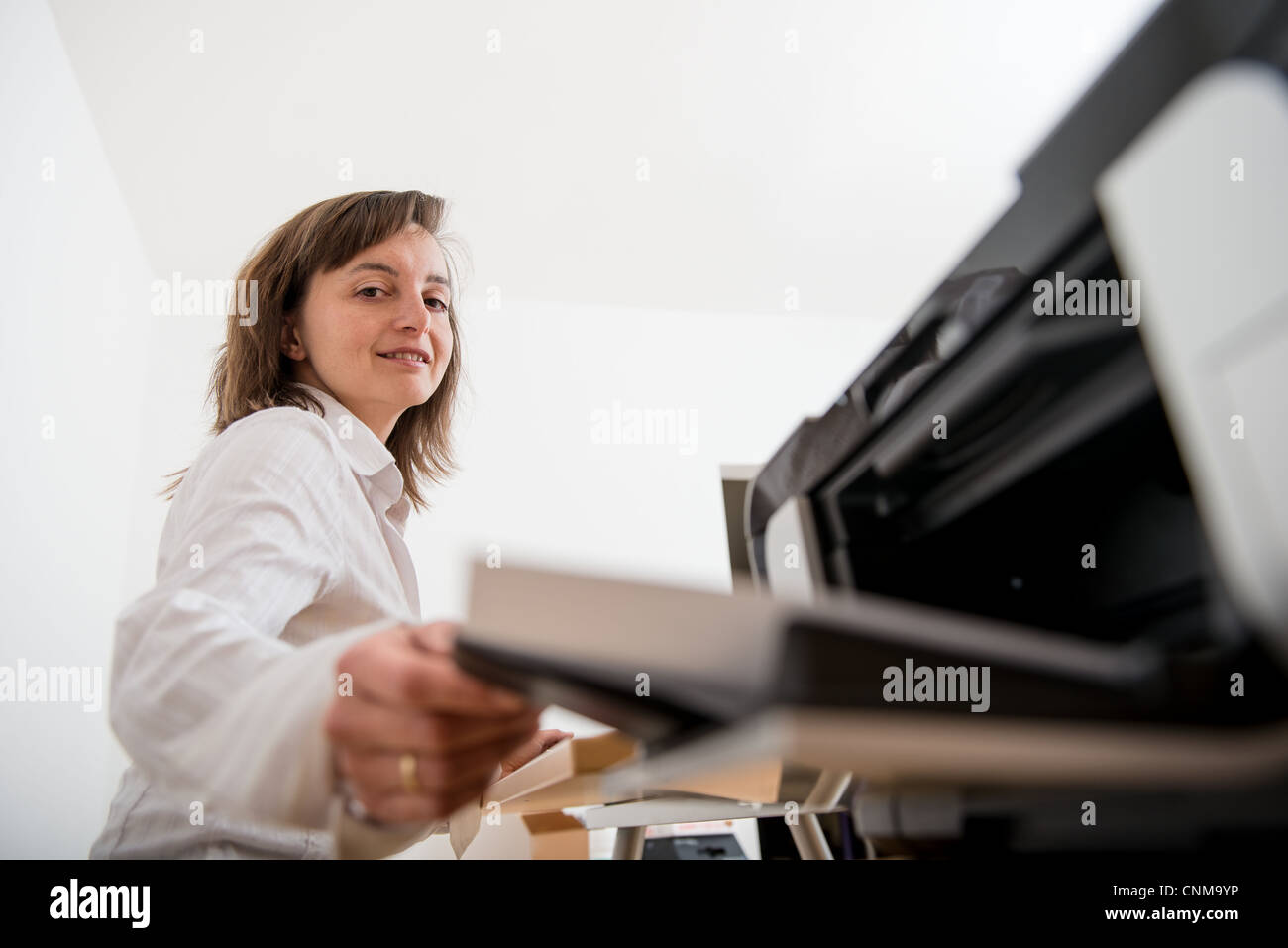 Business person reaching hand and taking paper from printer on ...