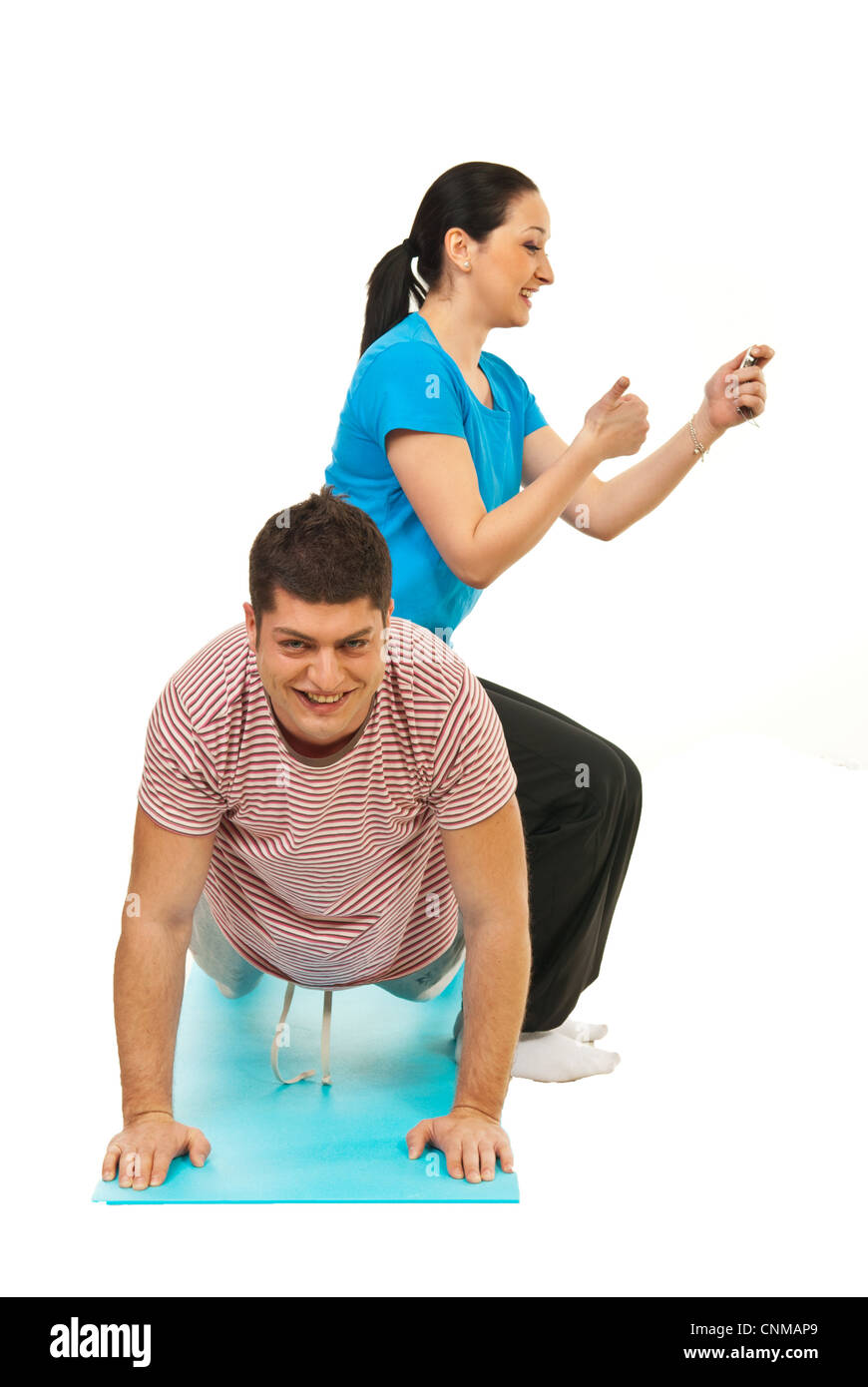 Man doing hard push ups with girlfriend on his back who holding ...