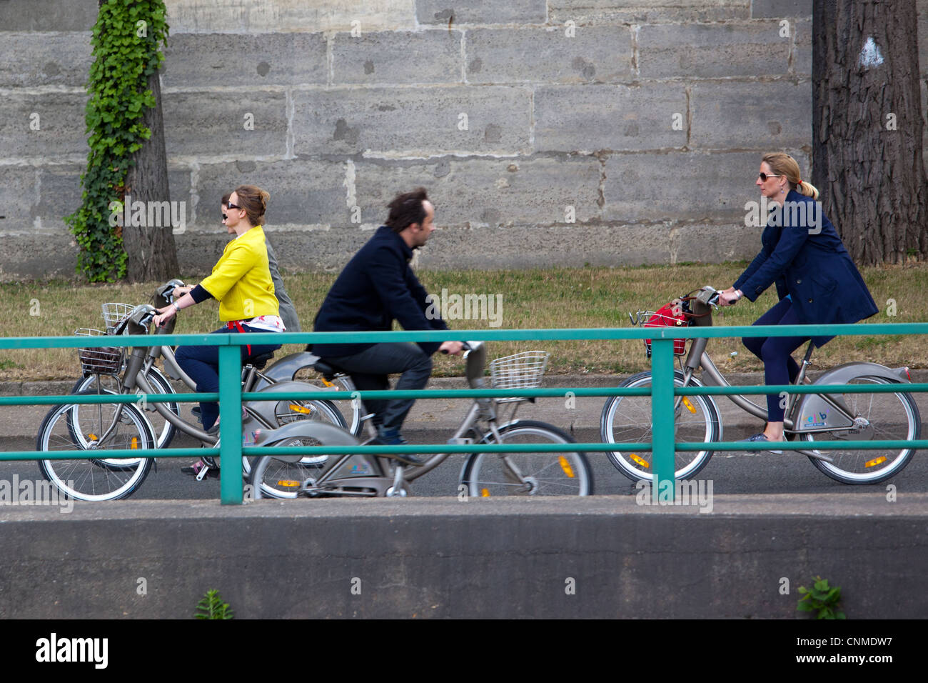 Four cyclists riding along a road by the River Seine in Paris France ...