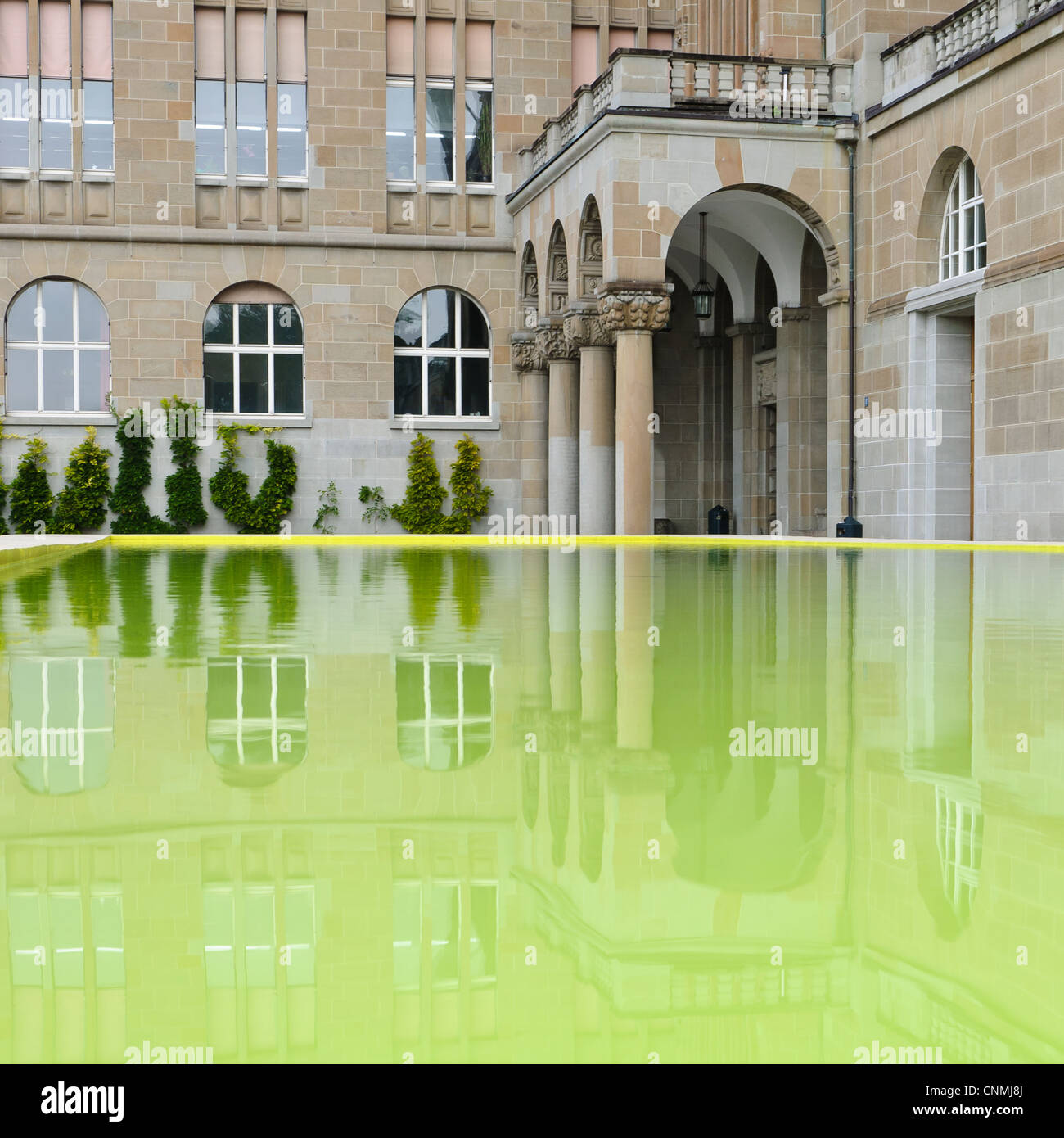 Zurich University building reflecting in a yellow water pool Stock ...