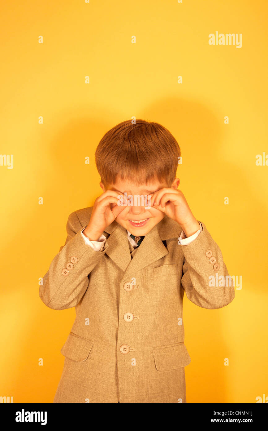 Boy closing eyes and covering them with his hands as an effect of ...