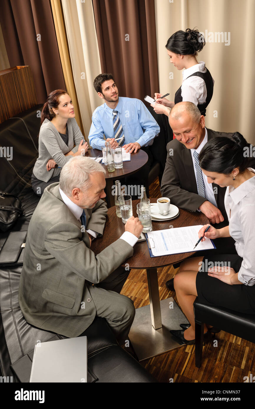 Business people having a company meeting at restaurant waitress ...