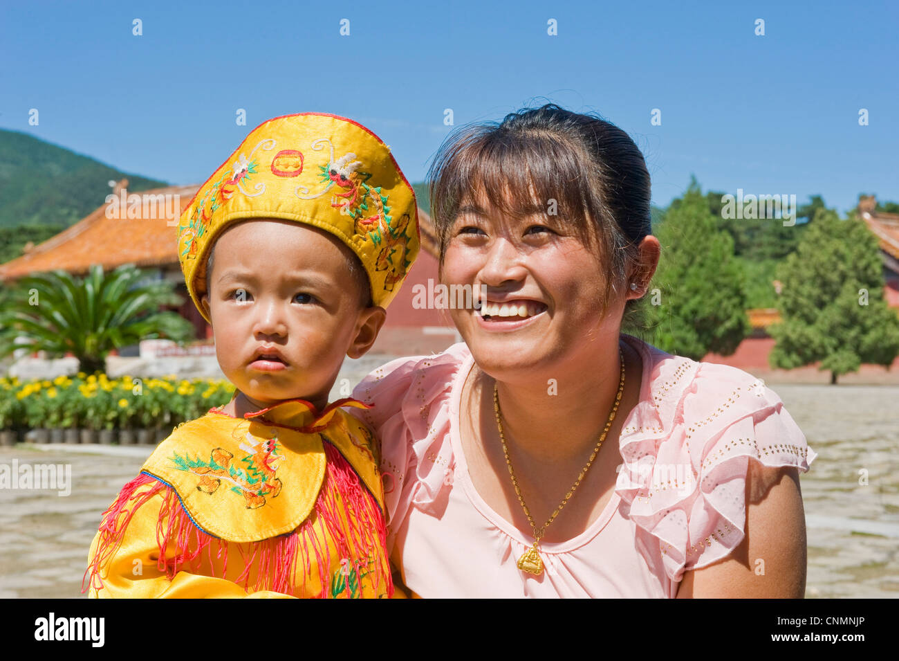 A young Chinese mother and her child dressed in traditional clothes ...