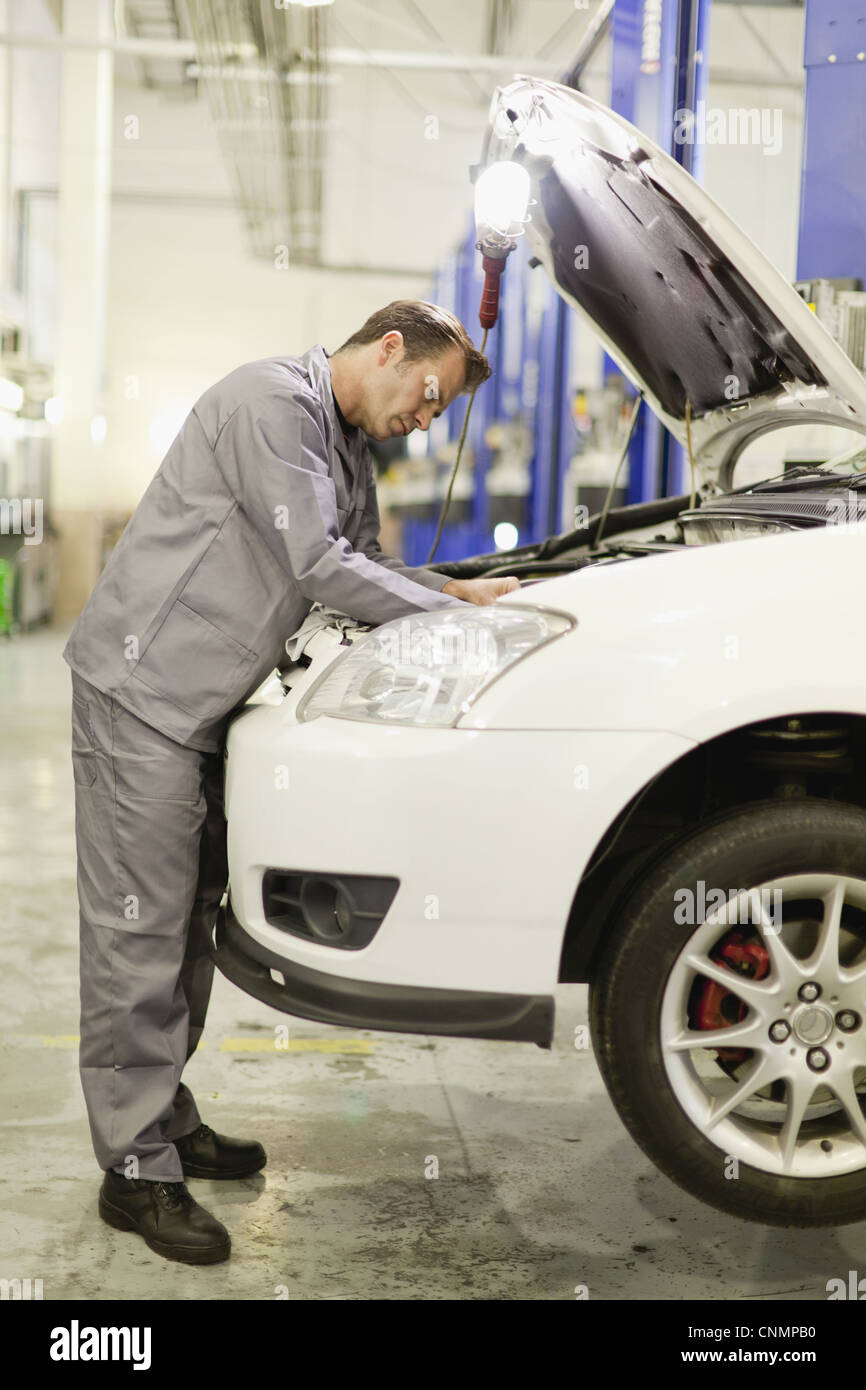 Mechanic working on car engine Stock Photo - Alamy