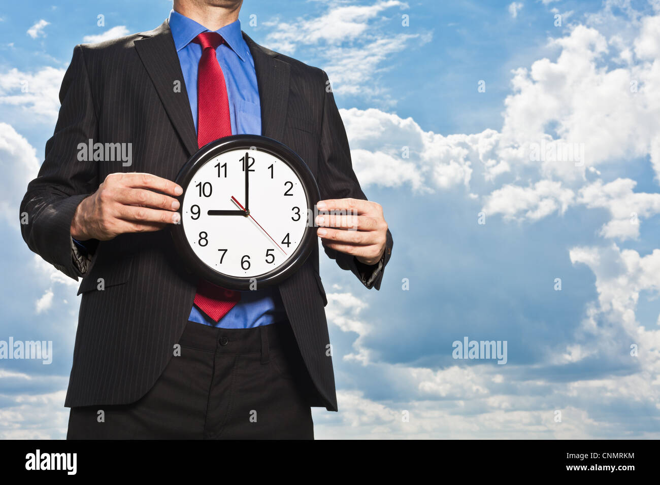 Businessman holding clock Stock Photo - Alamy