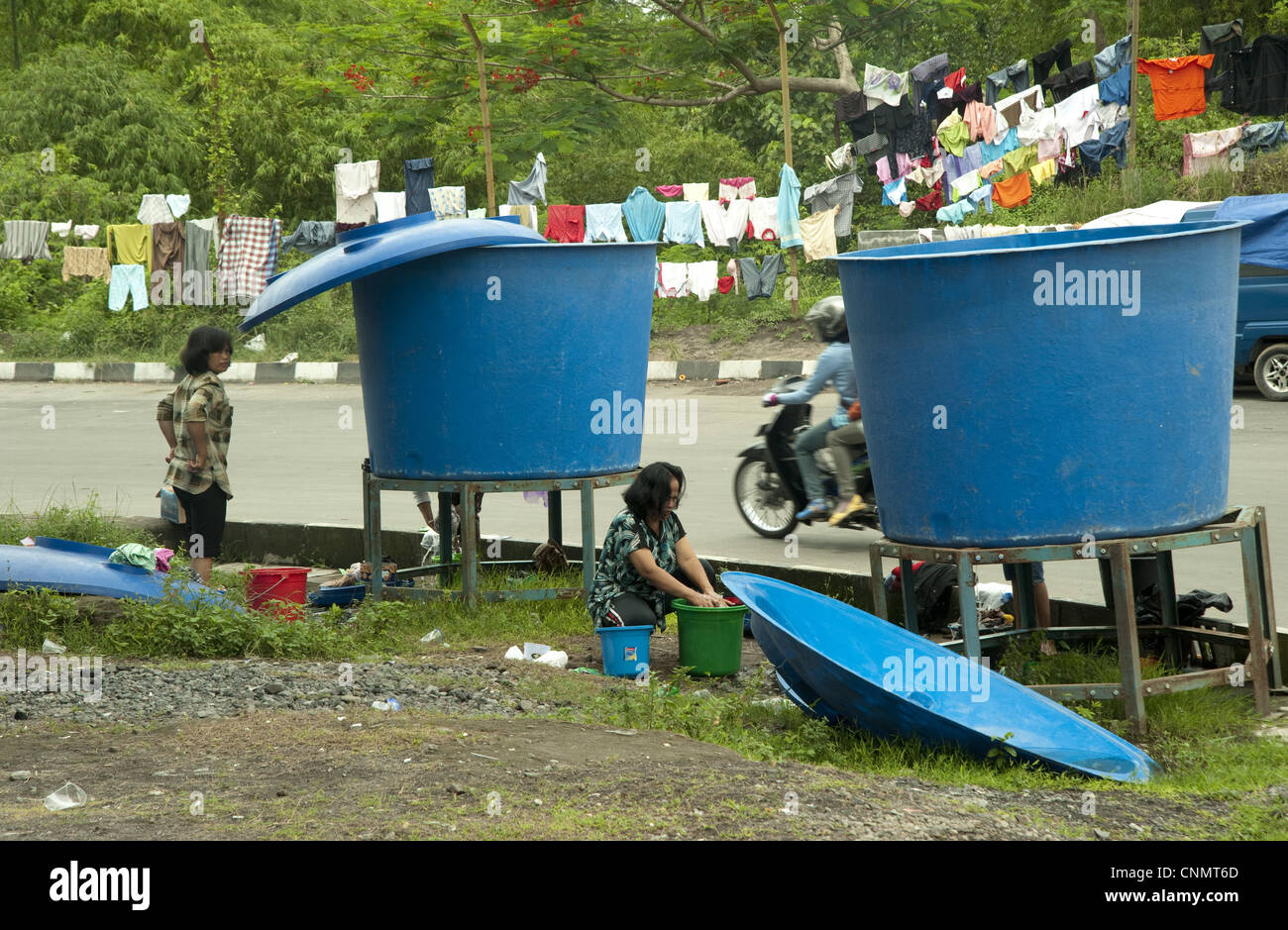 Refugees recent volcanic eruption washing clothes beside big vats water ...