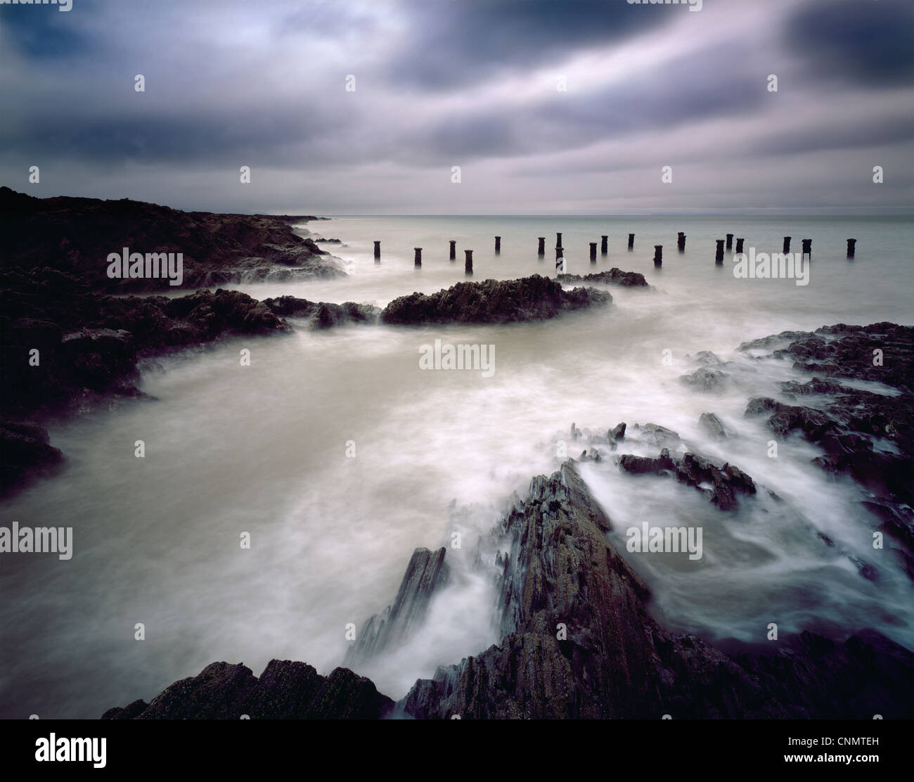 The pillars of the old pier under a grey stormy sky at Westward Ho! on ...