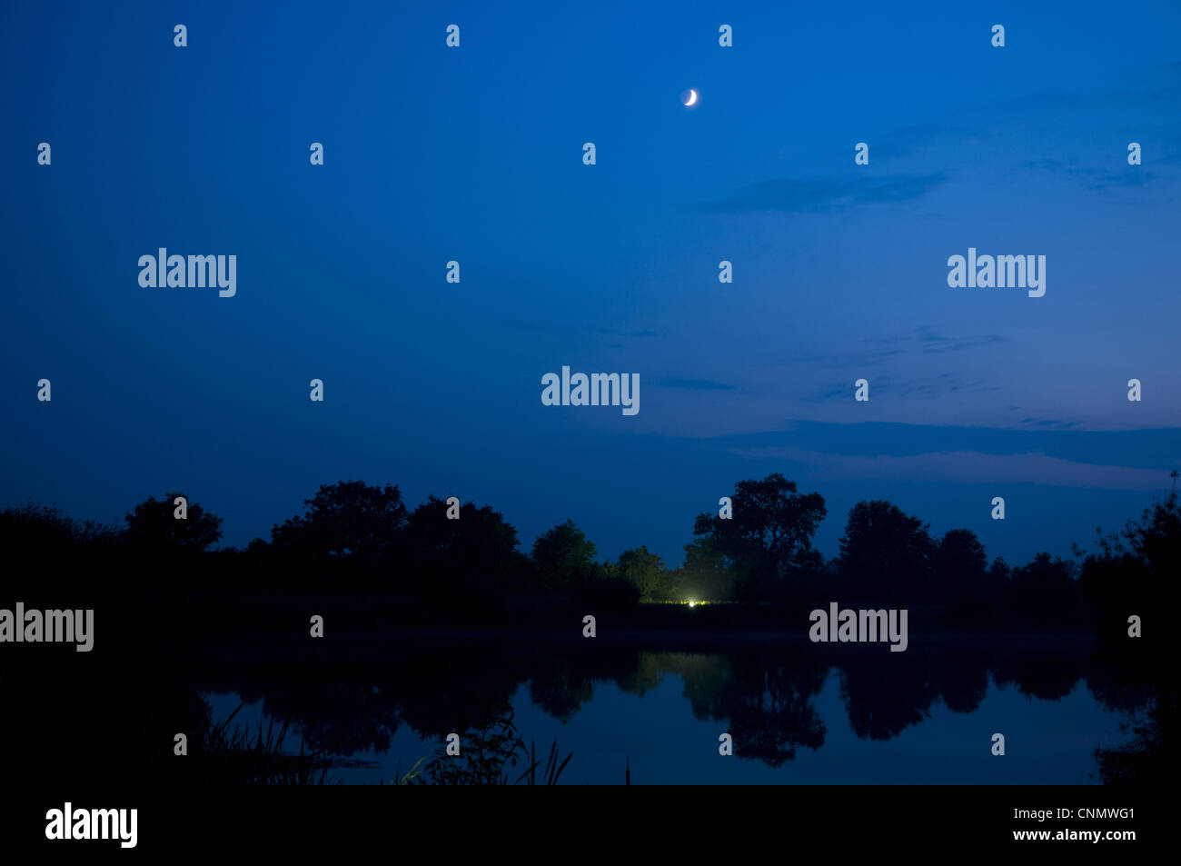 Crescent Moon above mercury vapour moth trap beside flooded former ...