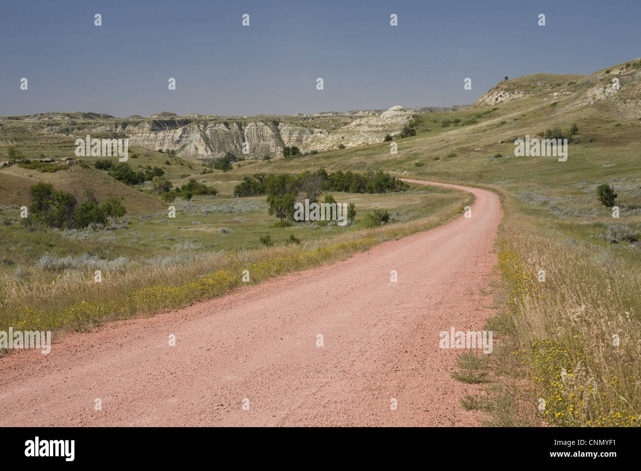View of red scoria road in ranch country, Badlands, North Dakota, U.S.A ...