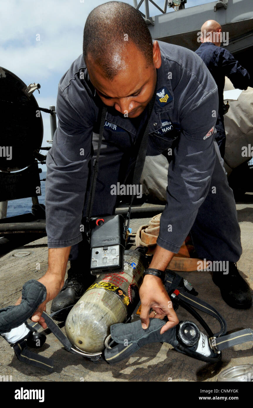 Hull Technician 1st Class (SW) Derek Glover lays a breathing apparatus ...