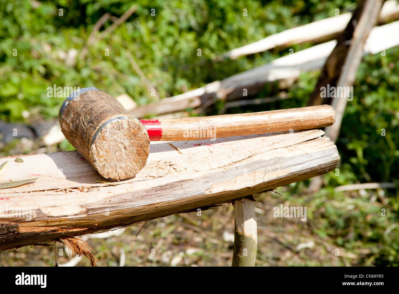 Wooden mallet resting on a piece of wood Stock Photo - Alamy