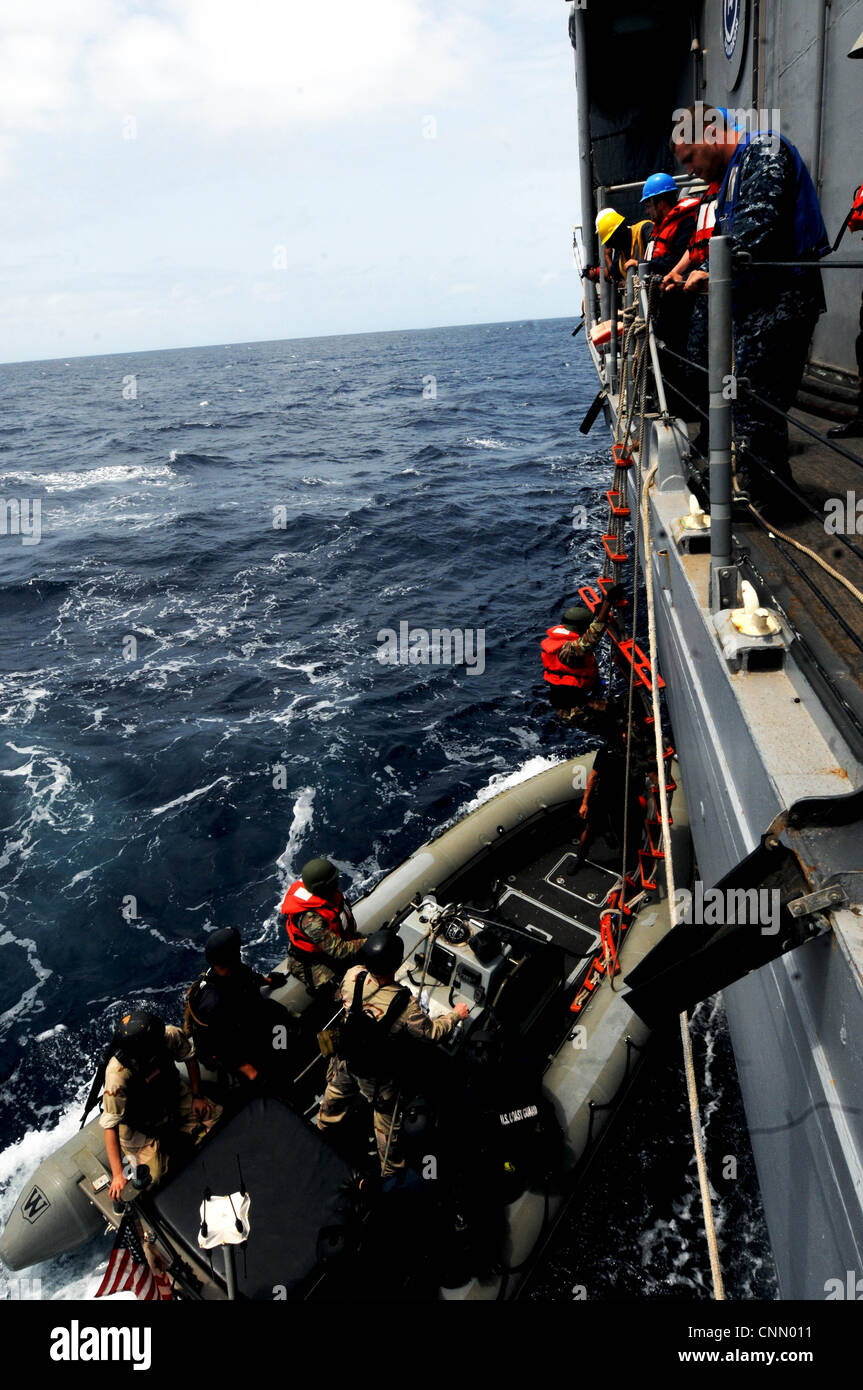 U.S. sailors and Coast Guardsmen board a rigid hull inflatable boat ...