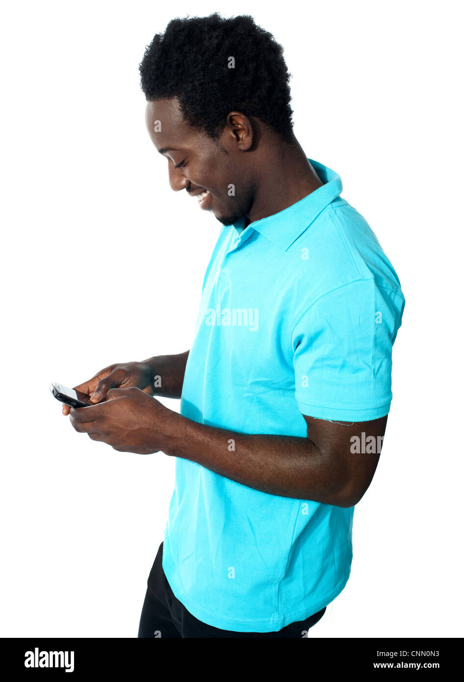 African boy busy messaging and smiling while reading message Stock ...