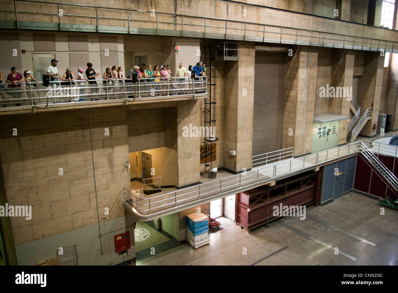 Tourist overlooking generator room as guide explains workings of ...