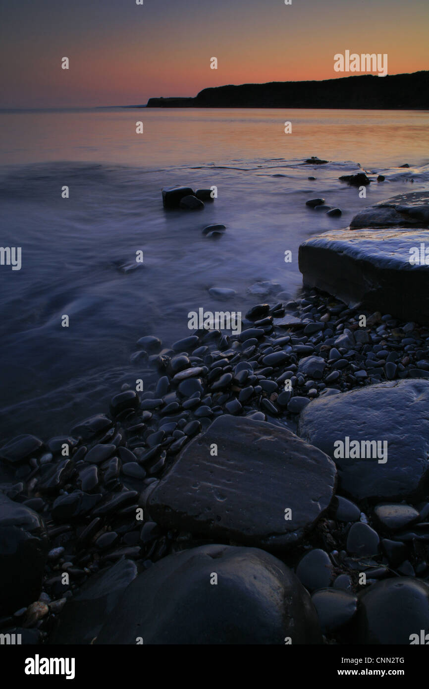 View of rocky beach with afterglow at sunset, Kimmeridge Bay, Isle of ...