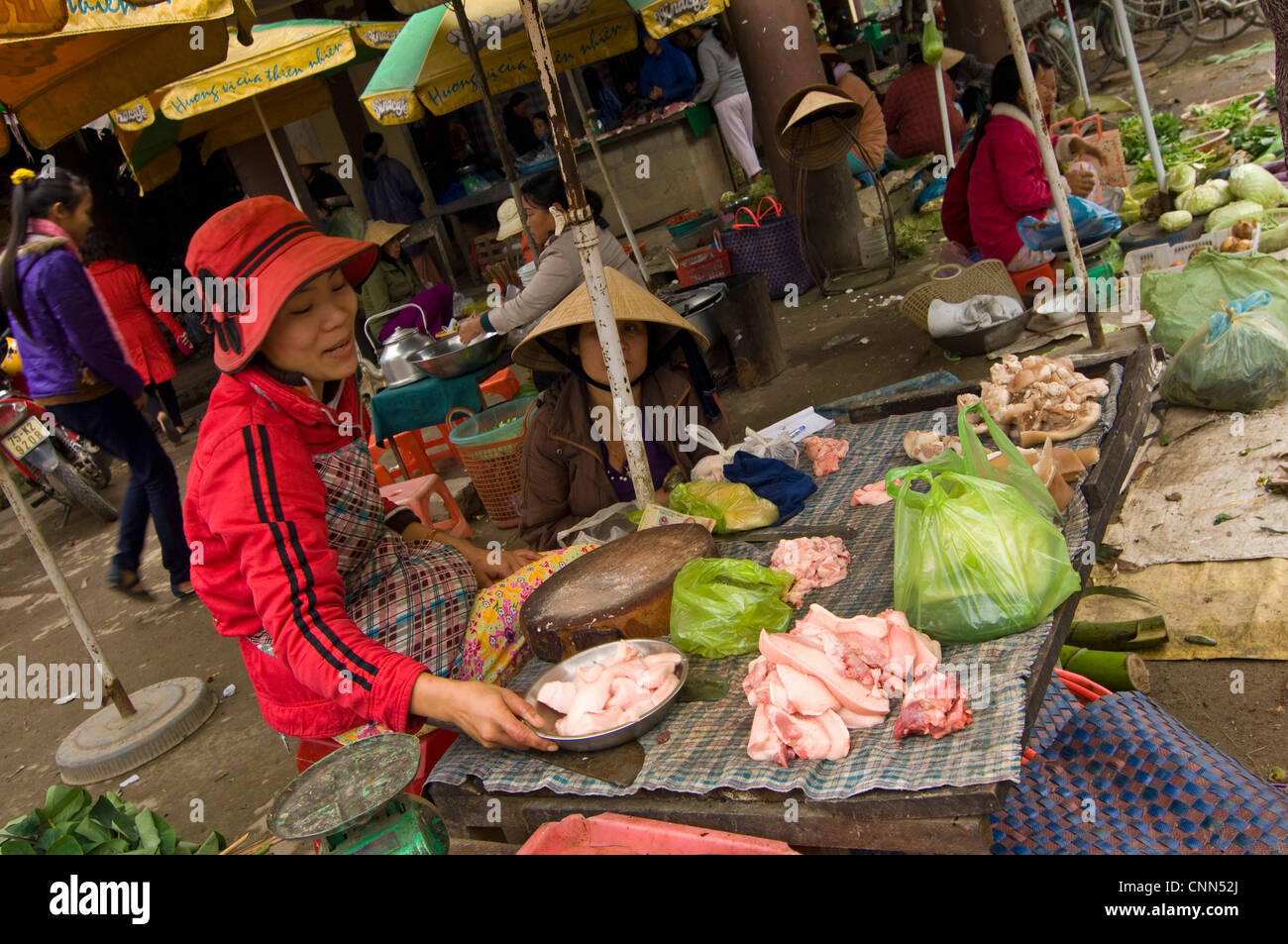 Horizontal portrait two women at a stall selling bits of meat in a ...