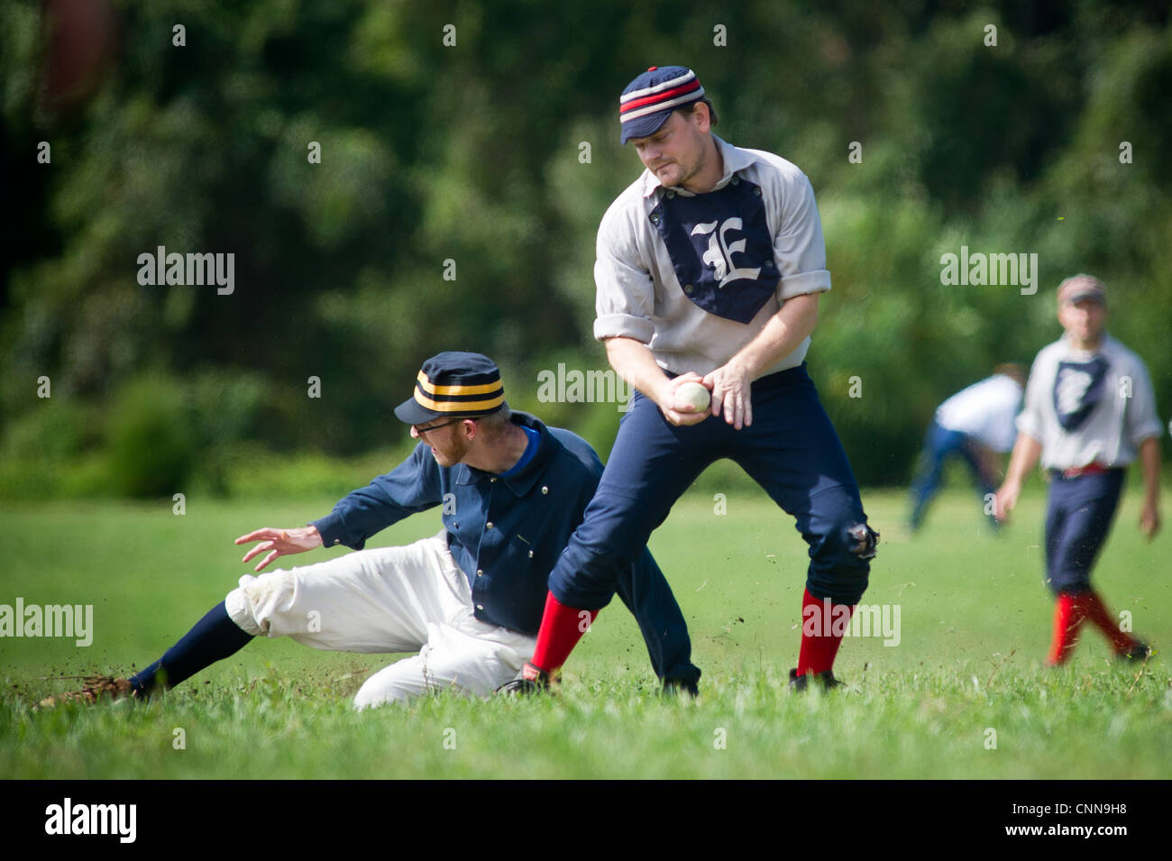 Second baseman and batter making a play dressed in vintage uniform ...
