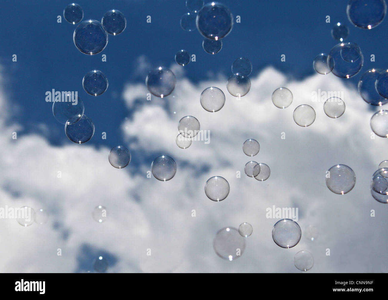 Bubbles flying in the sky passing the white clouds Stock Photo - Alamy