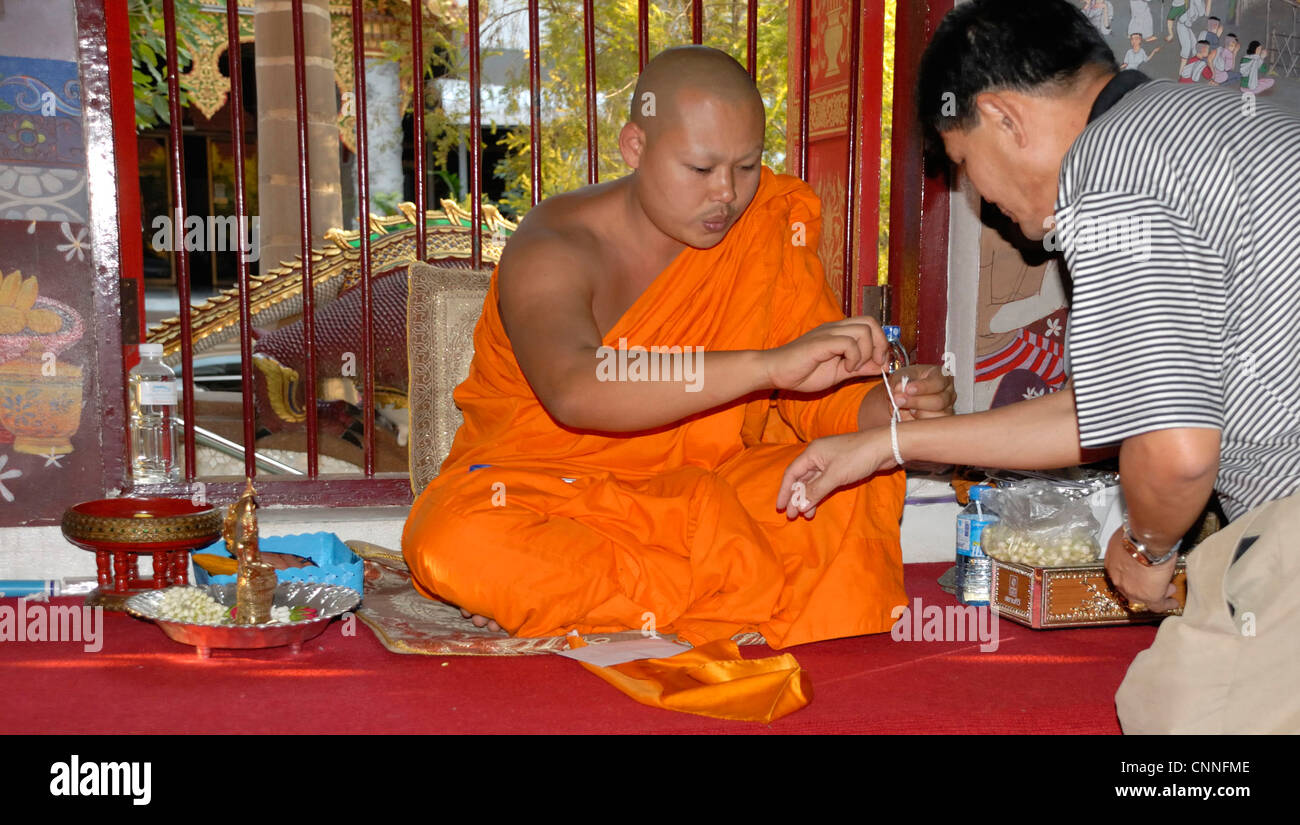 Monk giving bands for good luck and protection from bad things in ...