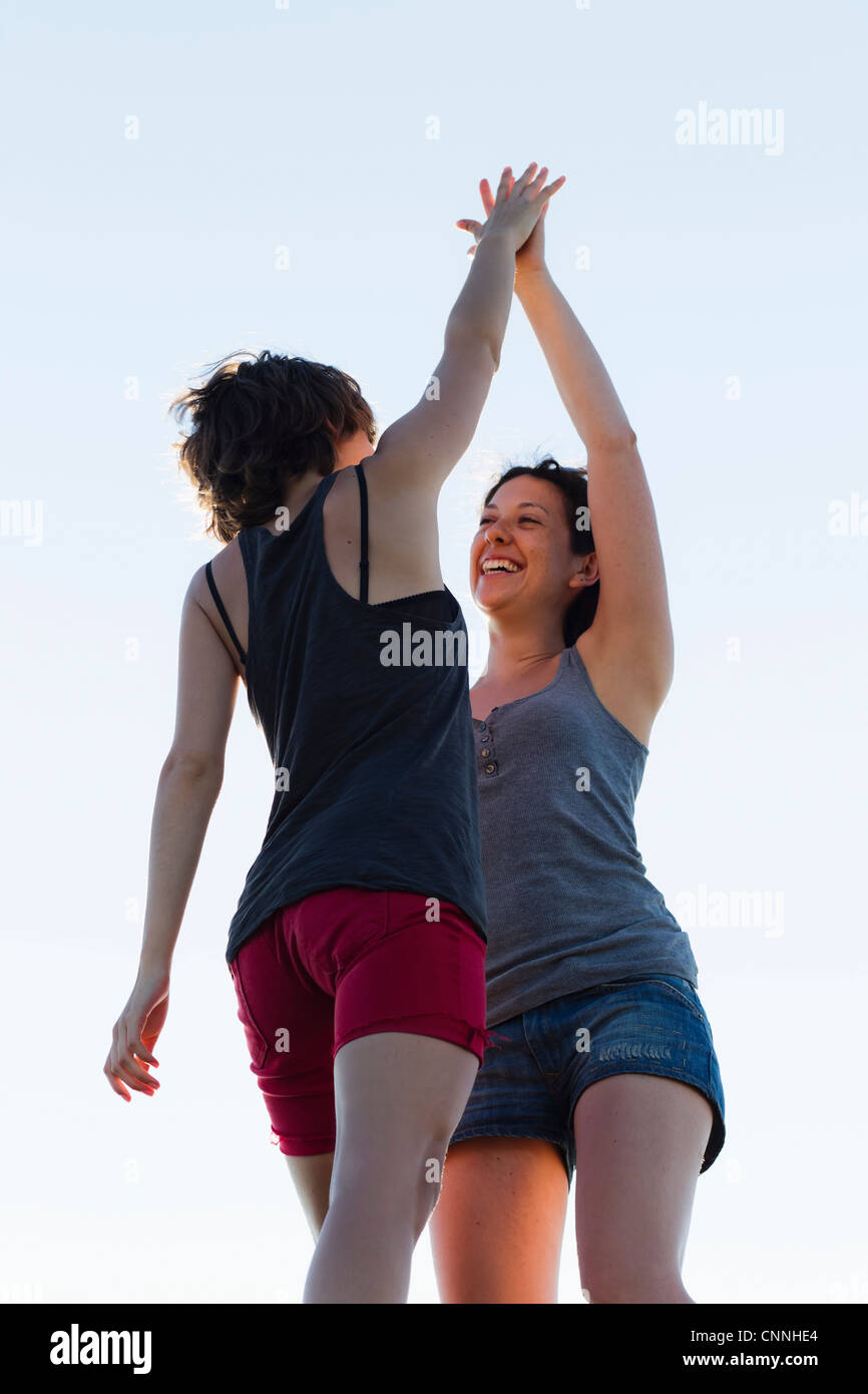 Women high-fiving outdoors Stock Photo - Alamy