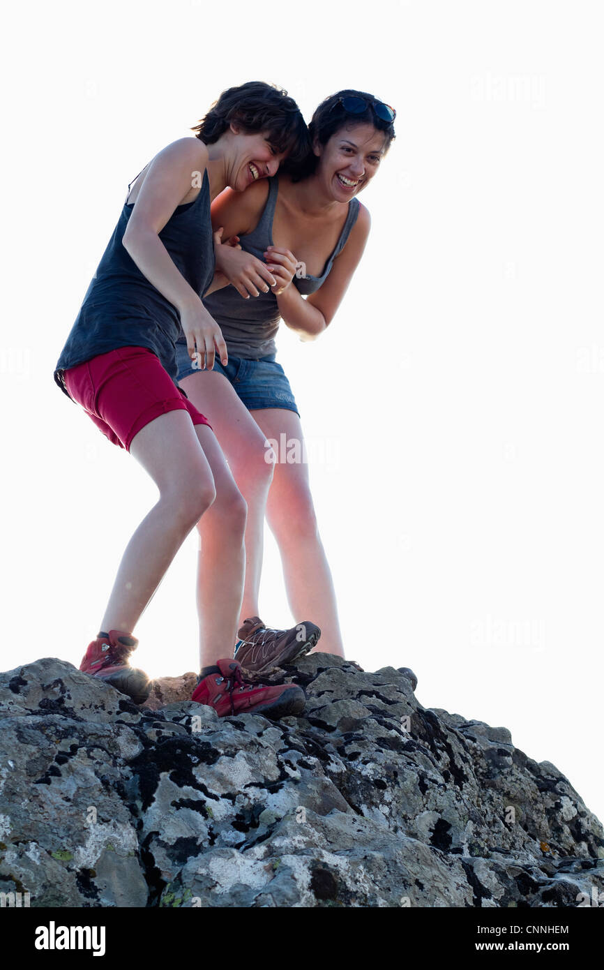 Hikers laughing on rock Stock Photo - Alamy