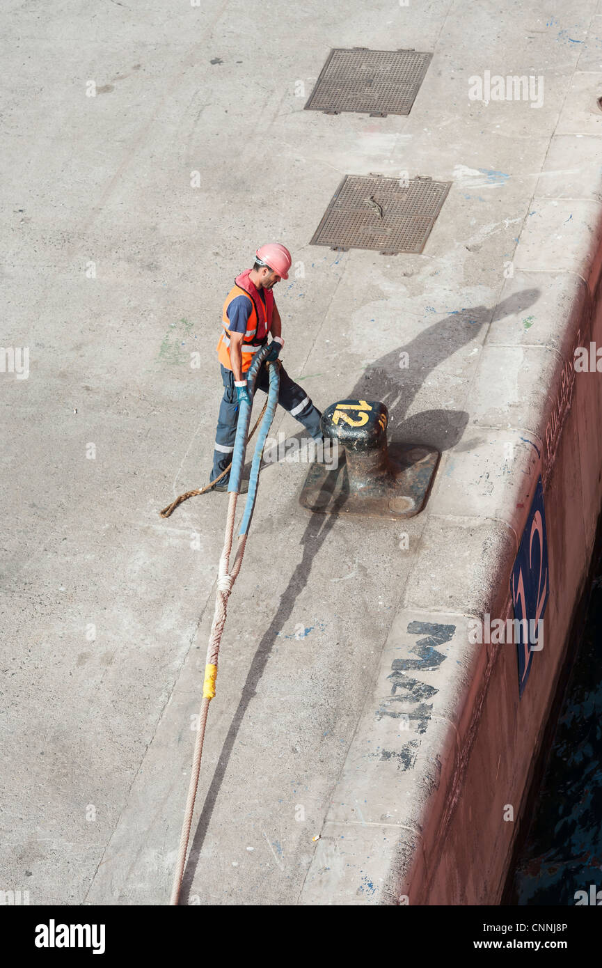 dock worker handling a mooring rope at a dock Stock Photo - Alamy