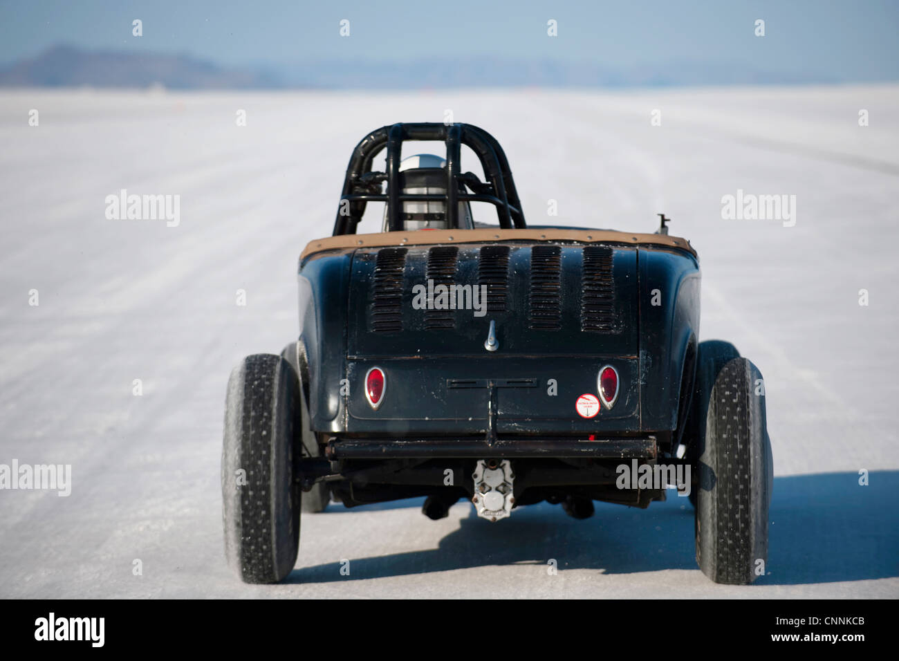 vintage retro car driving across bonneville salt flats US blue sky ...