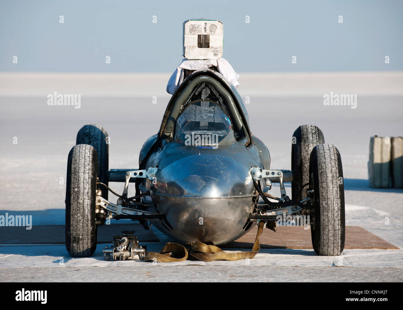 retro car driving across bonneville salt flats US blue sky white sand ...