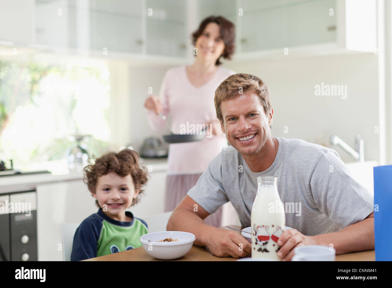 Family eating breakfast in kitchen Stock Photo - Alamy