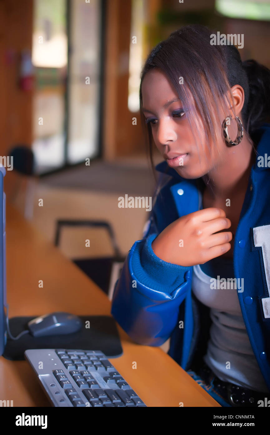 Young black woman sitting in front of a computer in a library Stock ...
