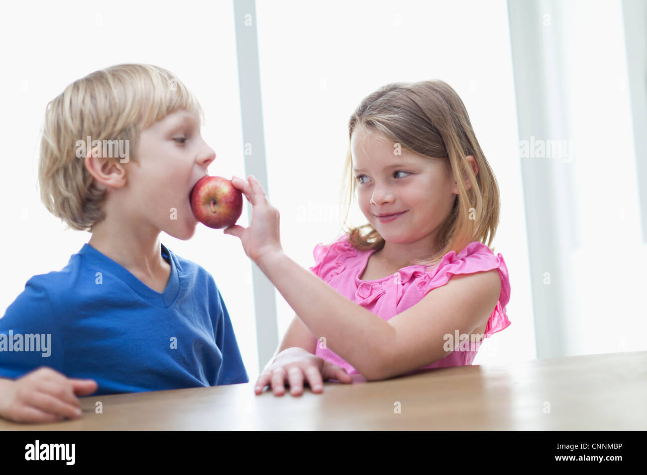 Children eating apple in kitchen Stock Photo - Alamy