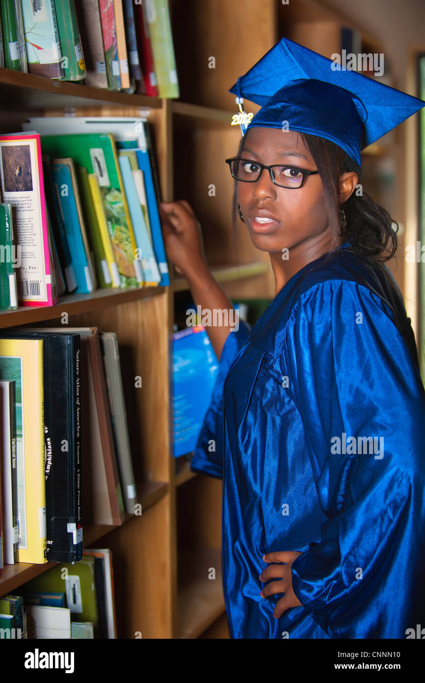Graduation student in cap and gown at library Stock Photo - Alamy