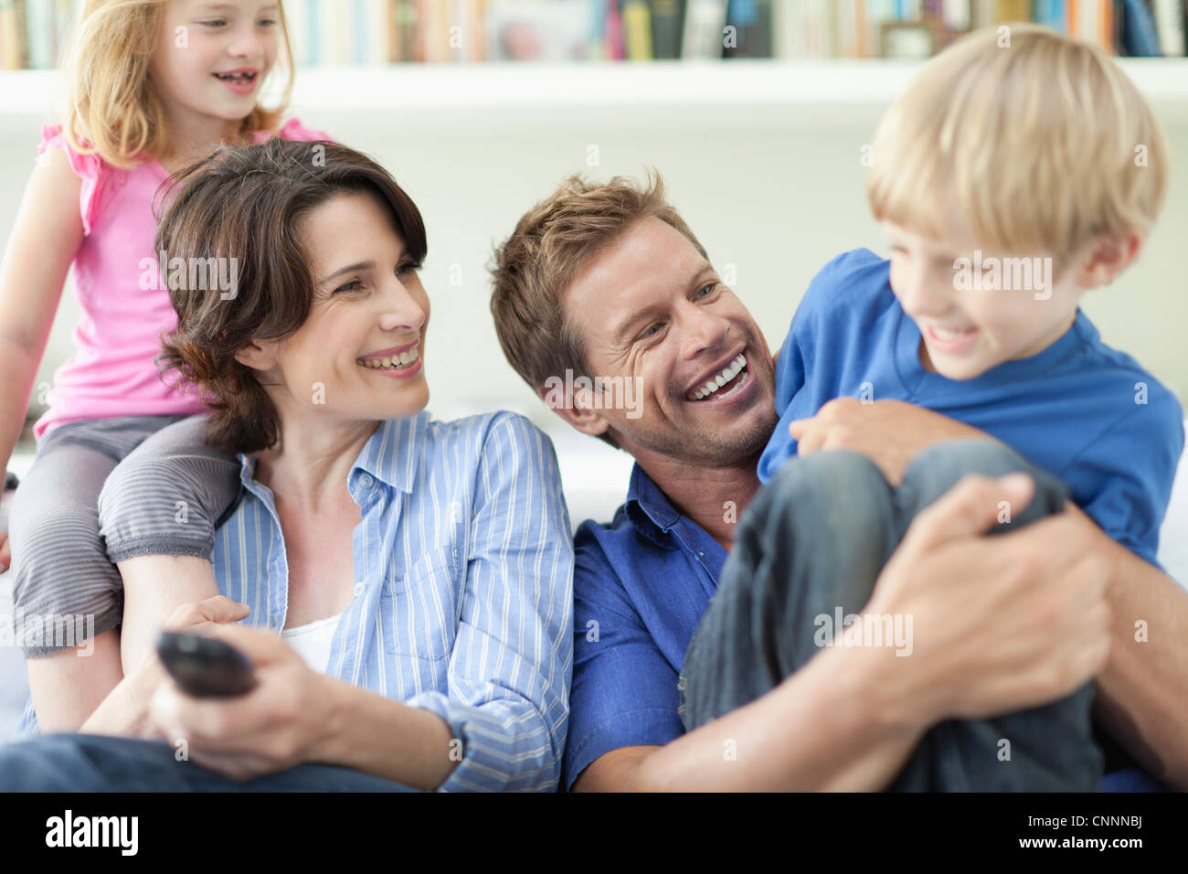 Family relaxing together on couch Stock Photo - Alamy